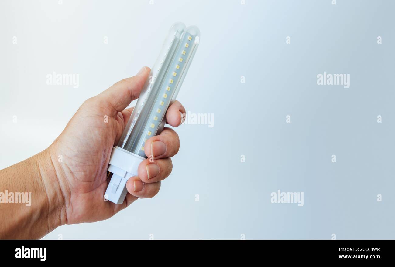 elongated led lamp held by man's hand isolated on light background ...