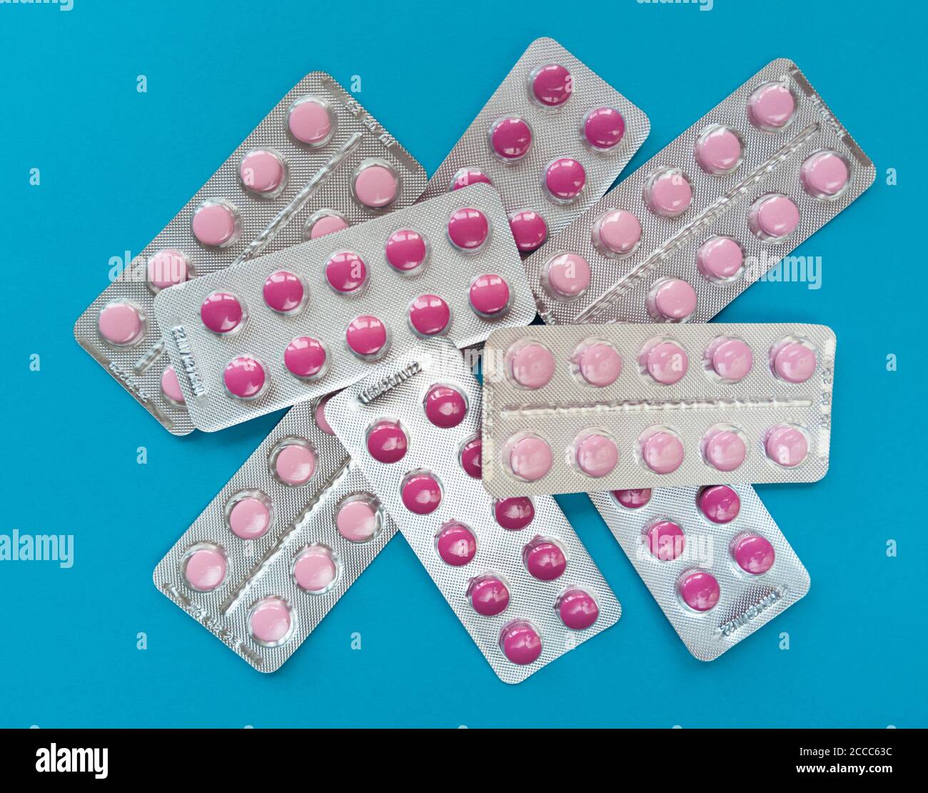A bunch of pink pills in blisters on blue backgrounds. Medical concept ...