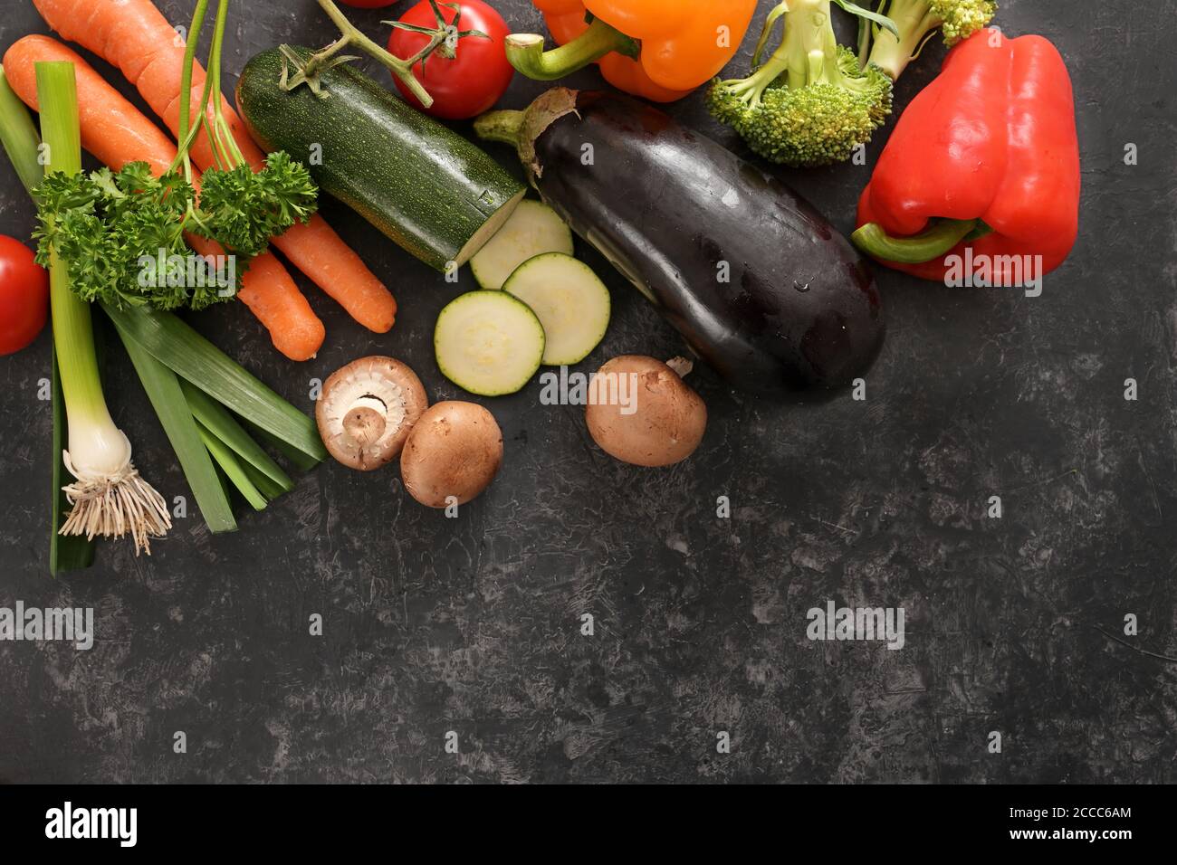 Colorful organic vegetables on a dark gray background with copy space ...