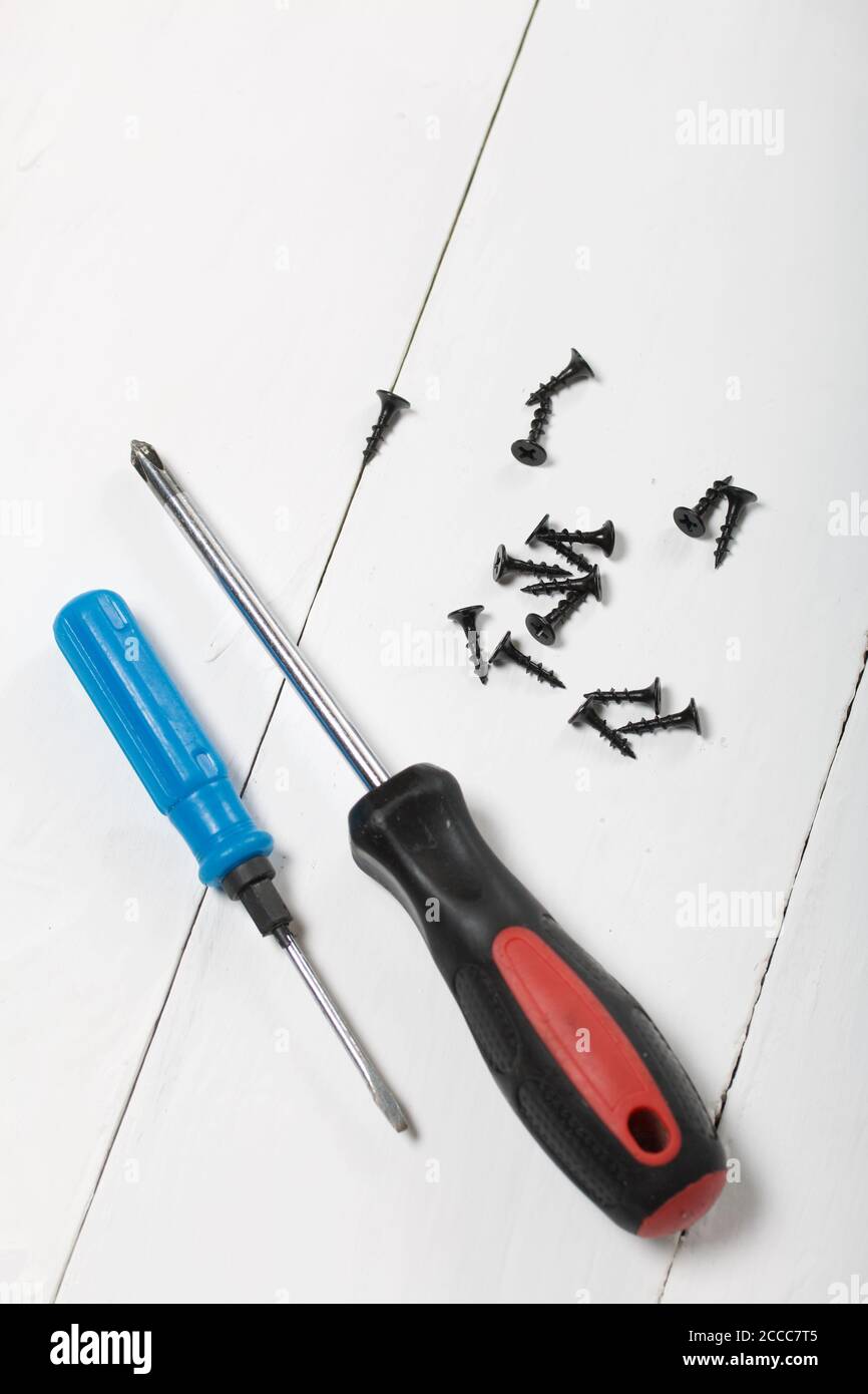 Two screwdrivers and a handful of screws. On white background Stock ...