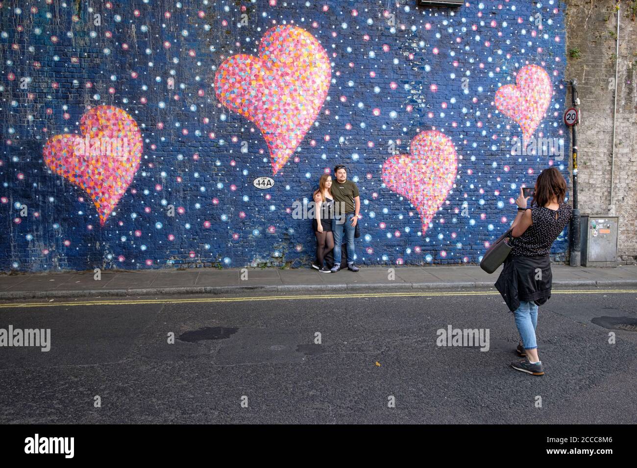 Photographer photographing couple in street hi-res stock photography ...