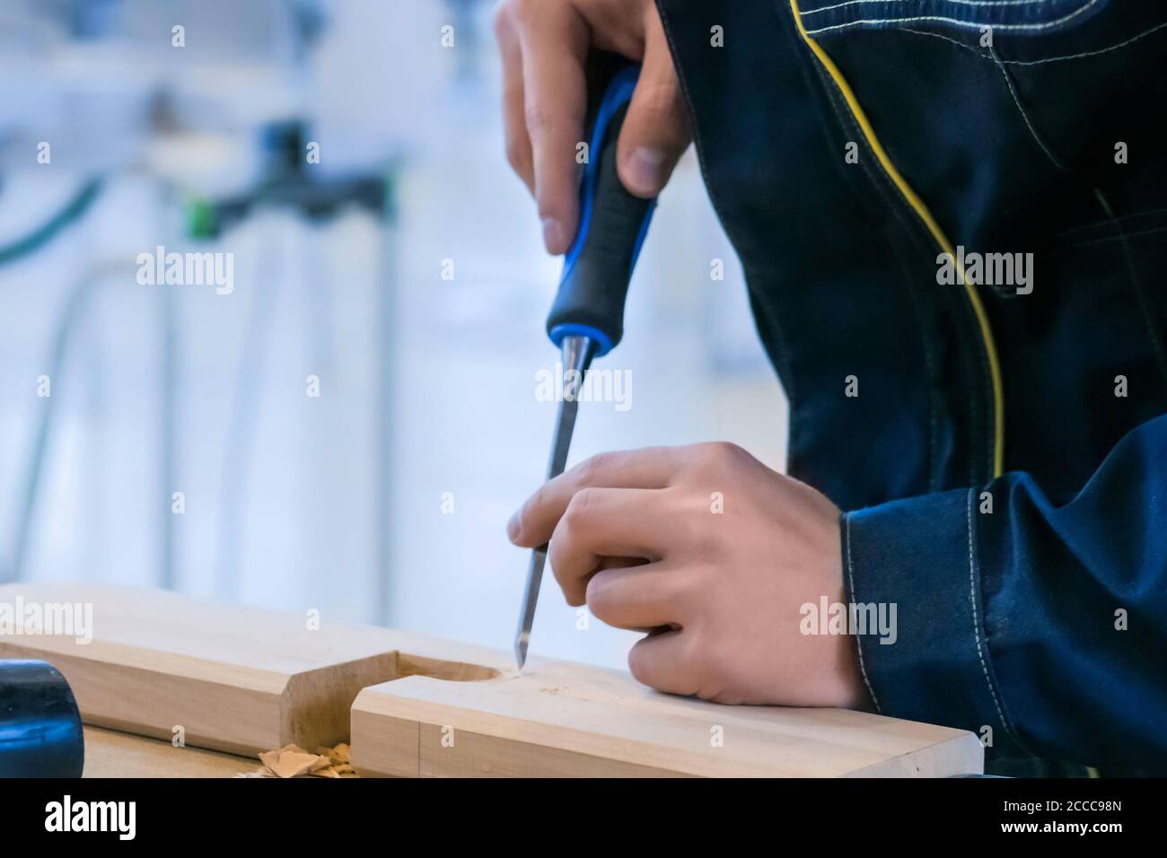 Professional man carpenter using chisel to carve wood on rough ...