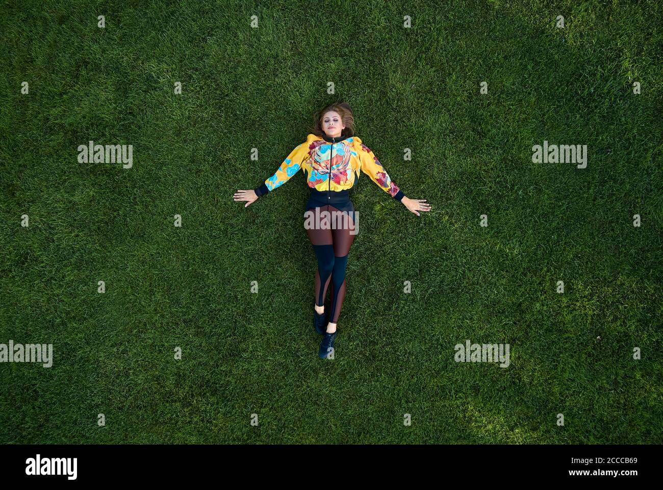 girl sitting on the grass, looking at the camera (top view Stock Photo ...