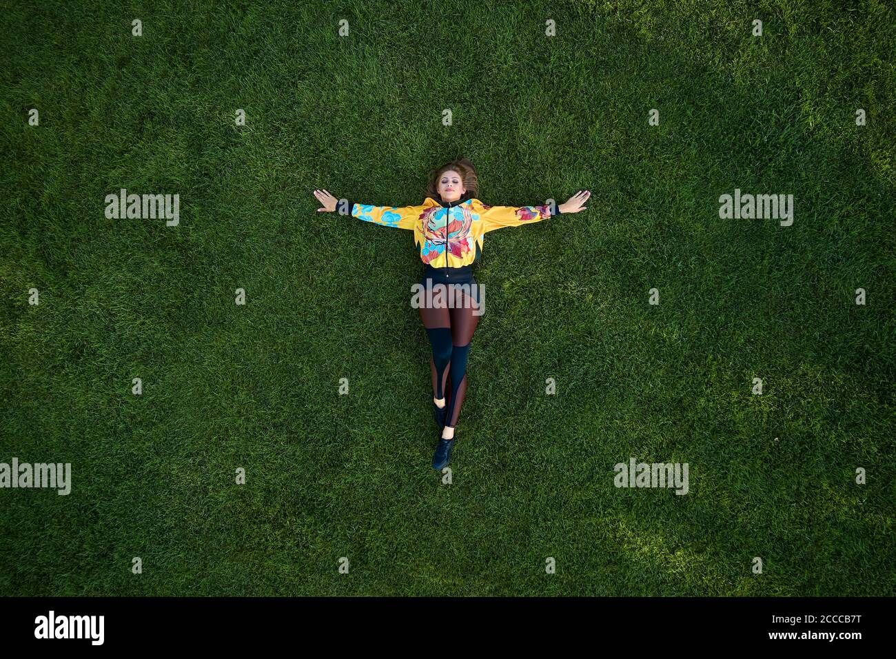girl sitting on the grass, looking at the camera (top view Stock Photo ...