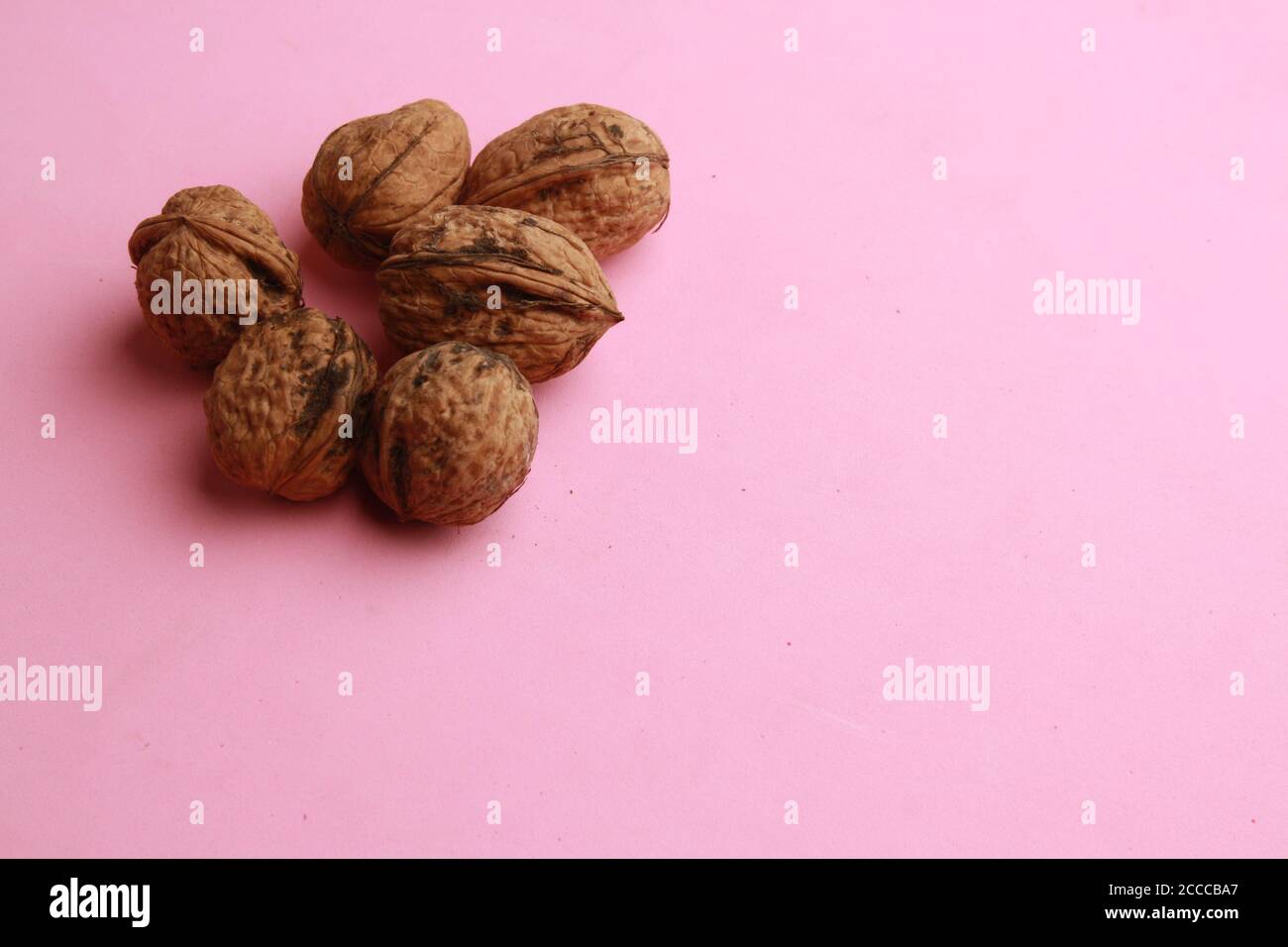 Closeup of a pile of walnuts on a pink surface under the lights Stock ...