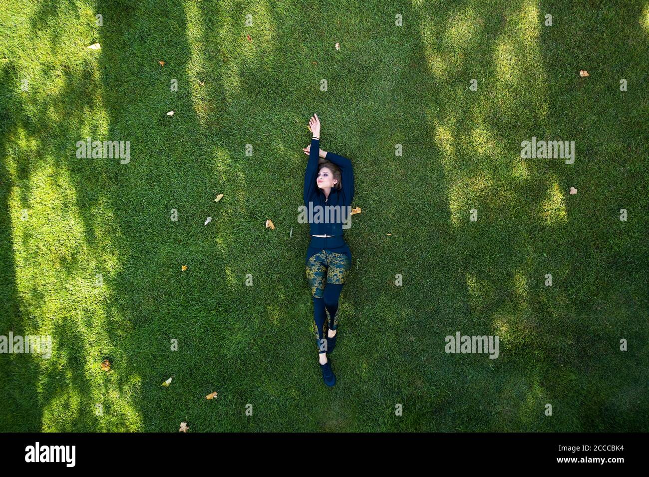 girl sitting on the grass, looking at the camera (top view Stock Photo ...
