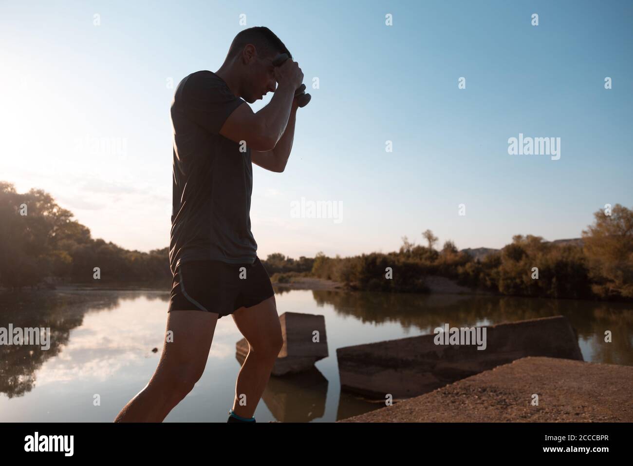 Closeup shot of a male training next to the river Stock Photo - Alamy