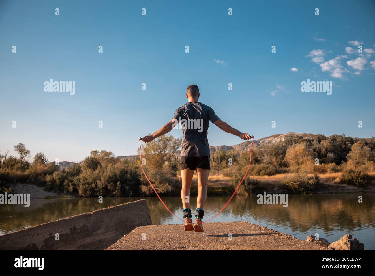 Male training with a jumping-rope next to the river Stock Photo - Alamy