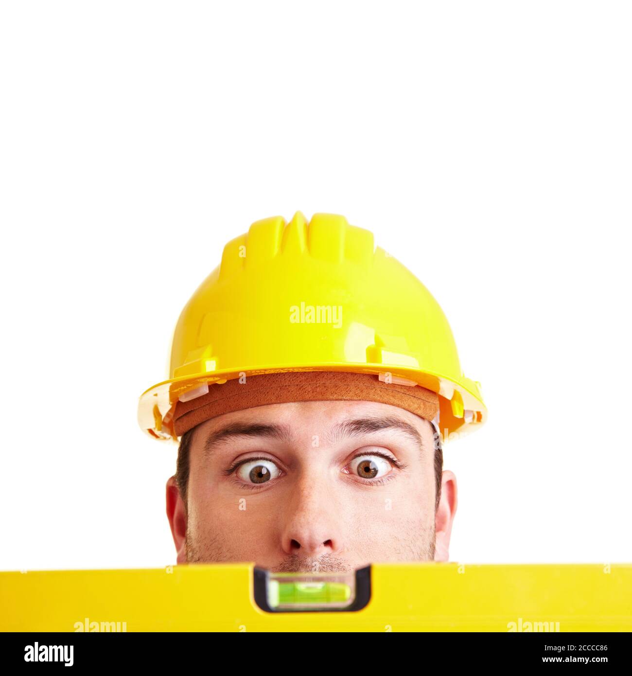 Craftsman looks in amazement at a yellow spirit level Stock Photo - Alamy