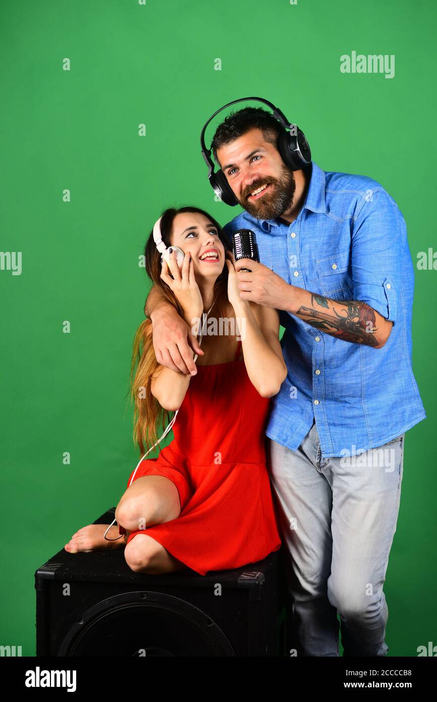 Couple in love wears headphones and holds microphone. Music and party ...