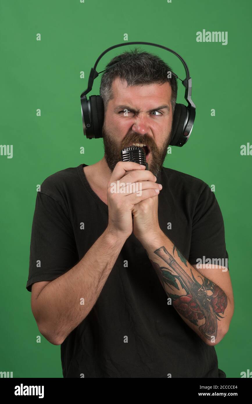 Singer with beard and wild face listens enjoys music. Man sings on ...