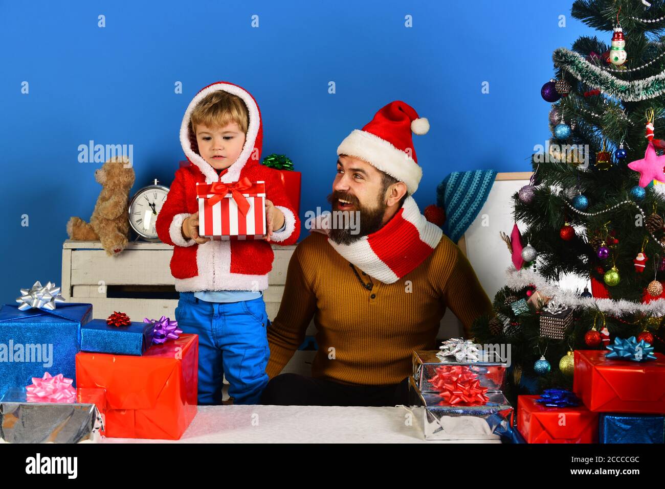 Christmas family opens presents on blue background. Santa and little ...