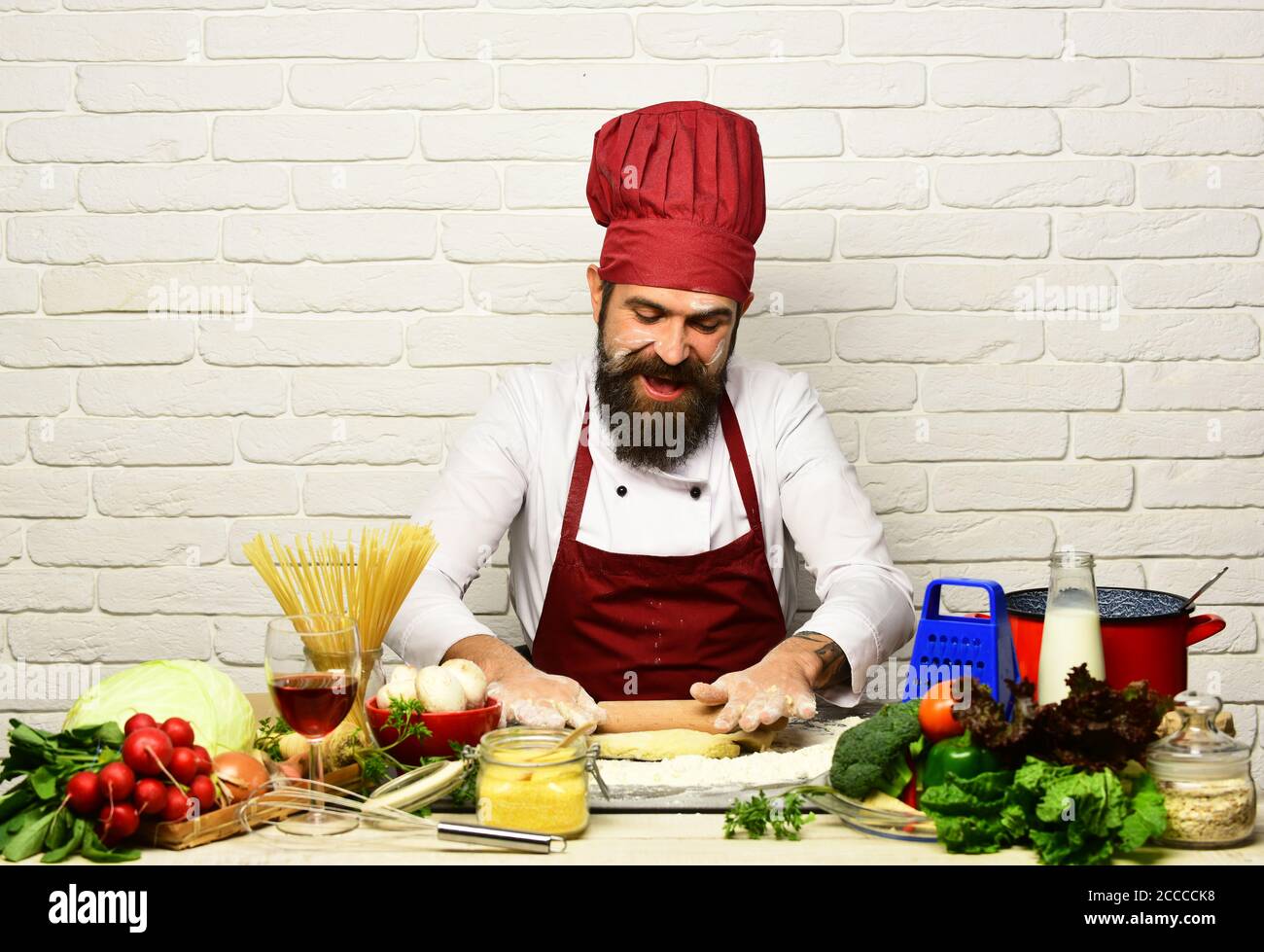Professional cookery concept. Chef makes dough. Man with beard rolls ...