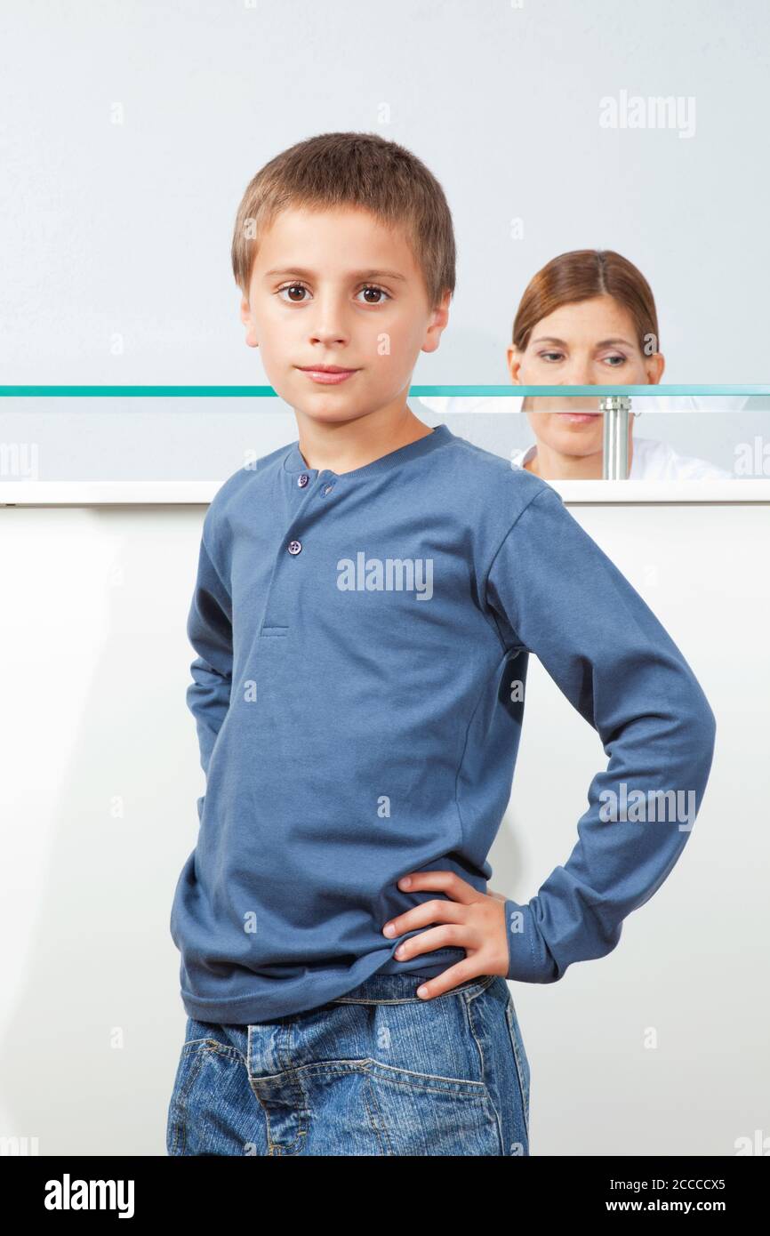 Child stands at the registration counter at the doctor Stock Photo - Alamy