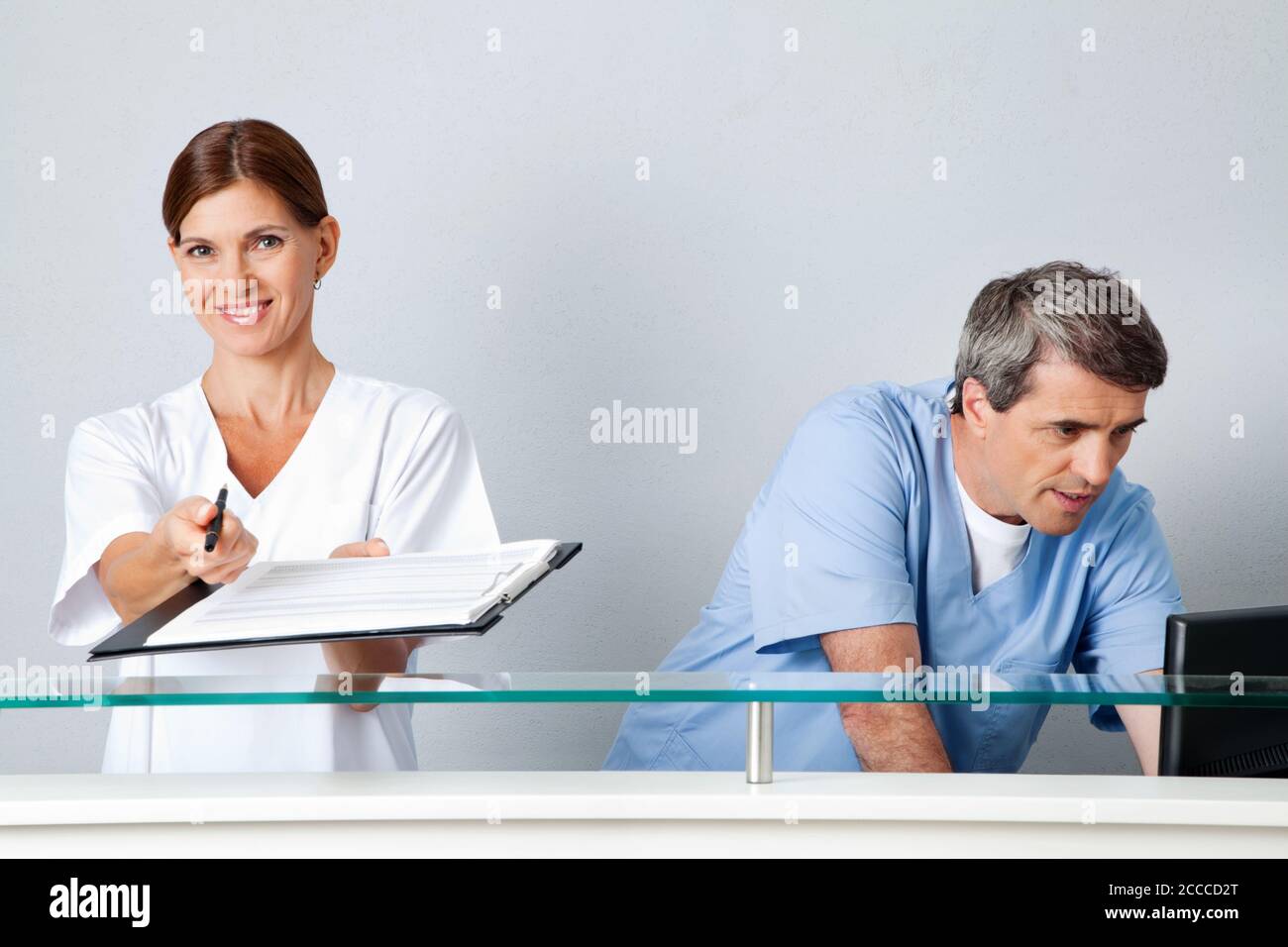 Female doctor asks for signature on a form on a clipboard Stock Photo ...