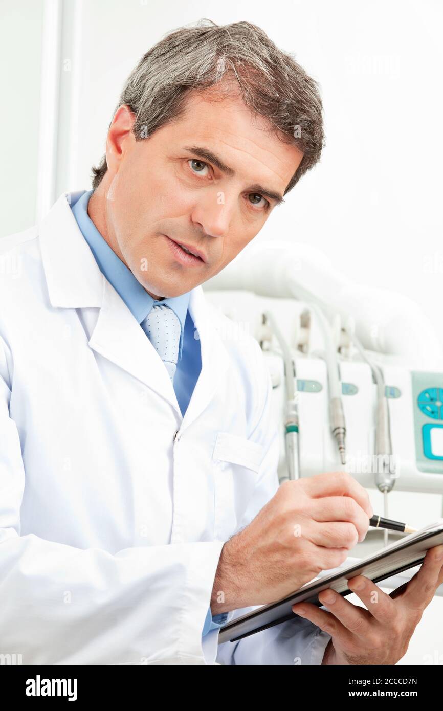 Dental expert with clipboard and checklist in practice Stock Photo - Alamy