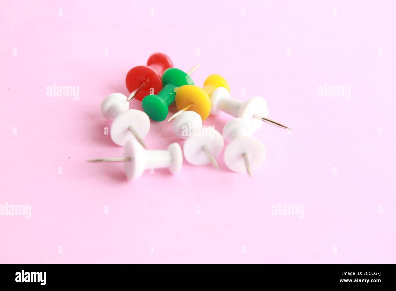 Plastic push pins on a pink surface Stock Photo - Alamy