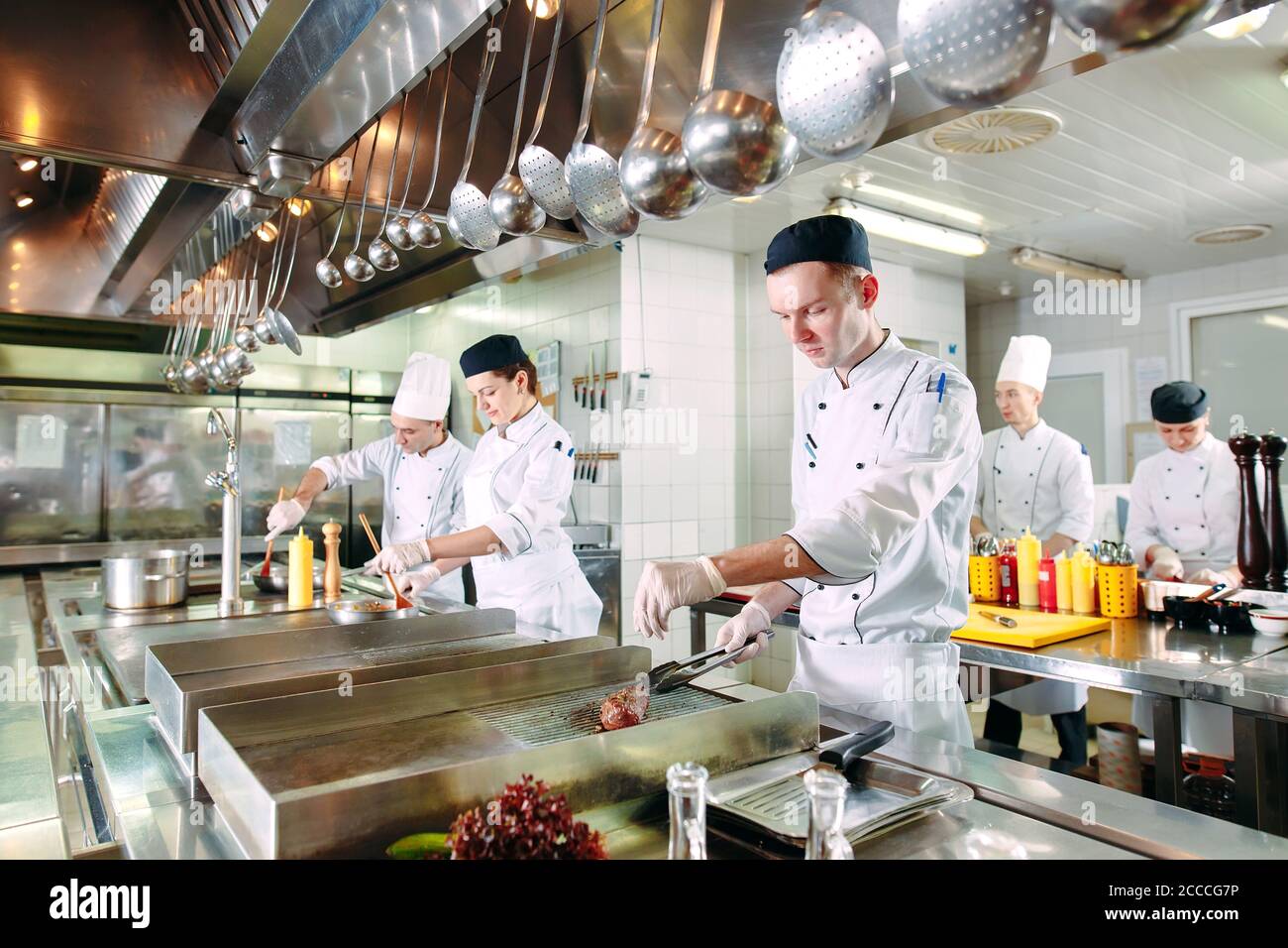 Modern kitchen. Cooks prepare meals on the stove in the kitchen of the ...