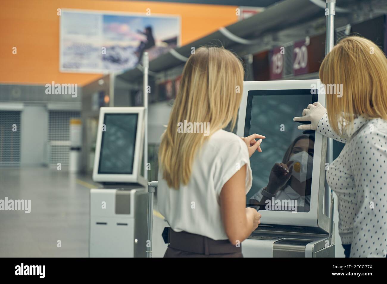 Worker of the airport helping to get boarding pass Stock Photo - Alamy