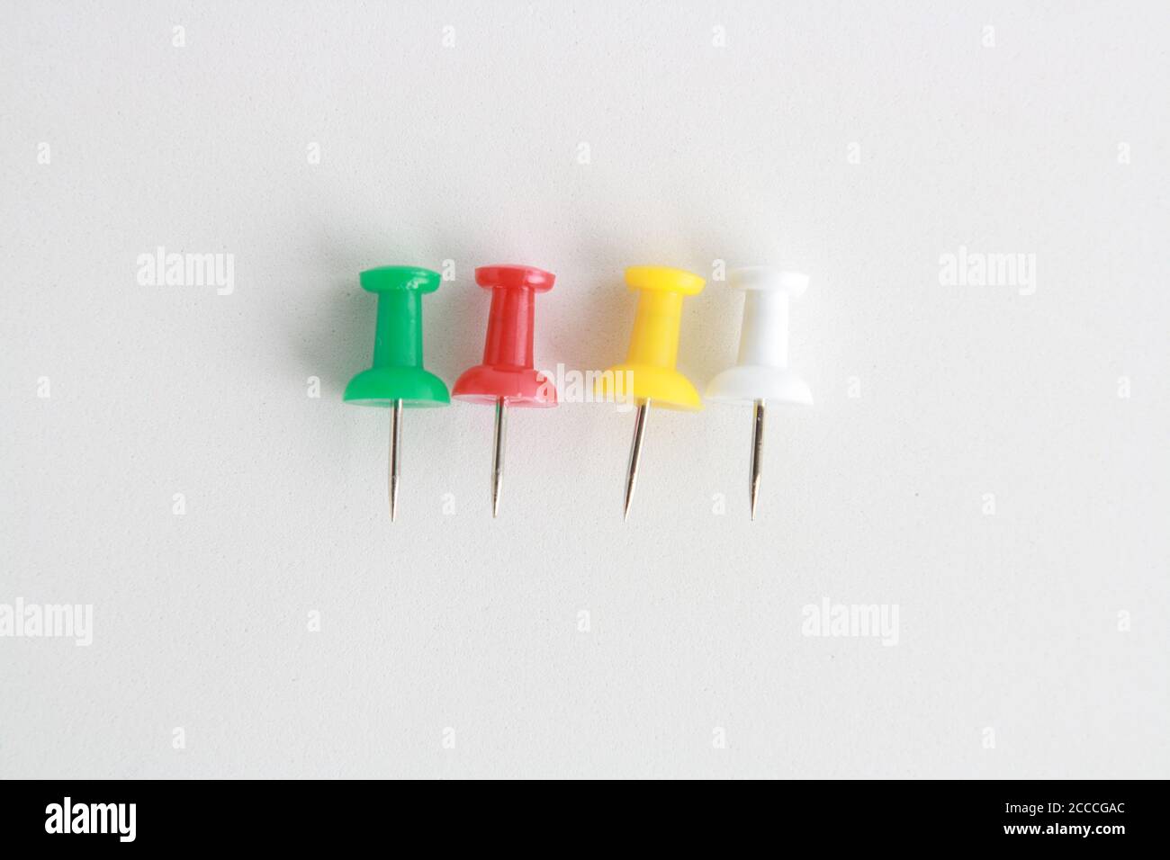 Plastic push pins on a white surface Stock Photo - Alamy