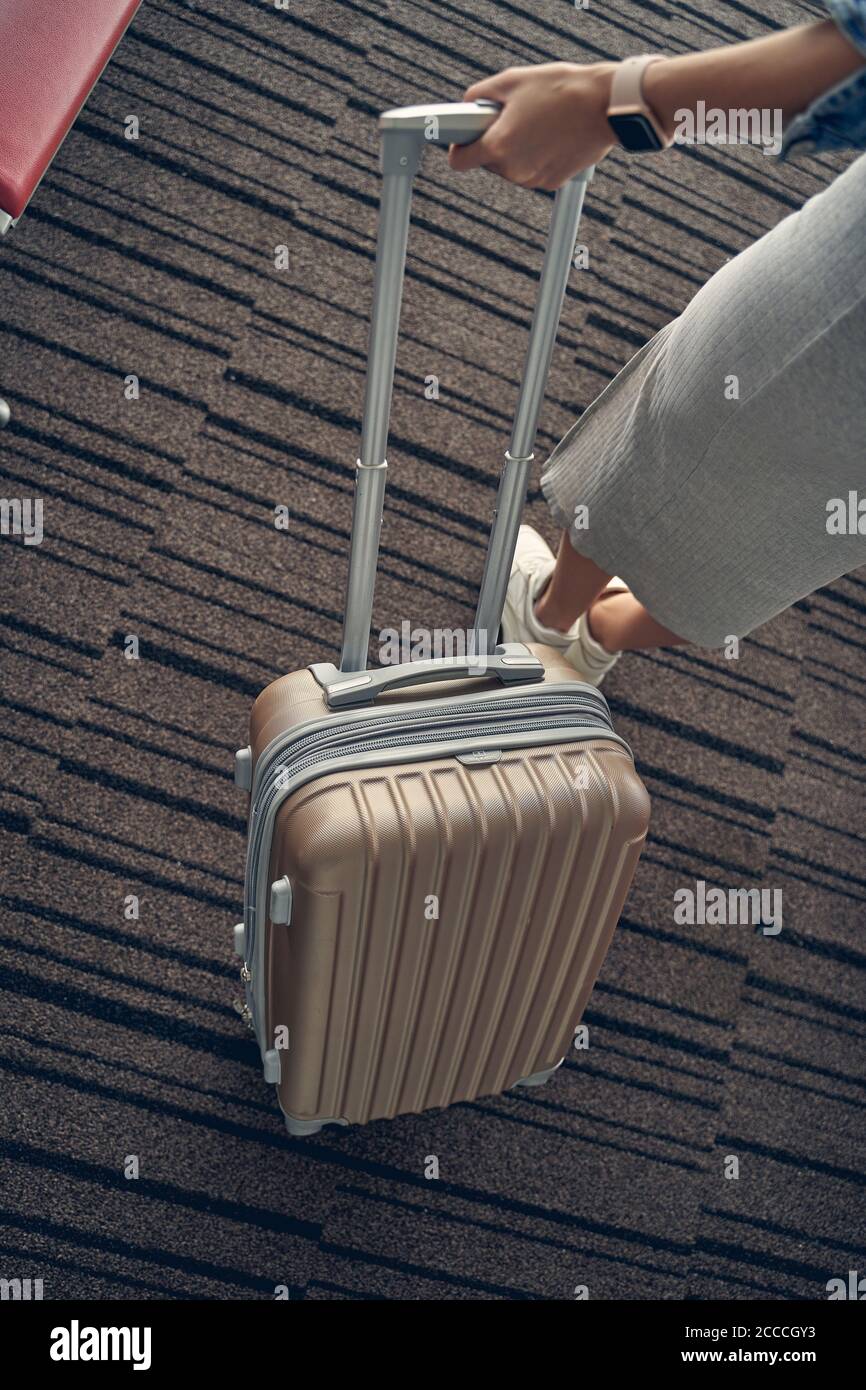 Focused photo on female hand pulling suitcase Stock Photo - Alamy