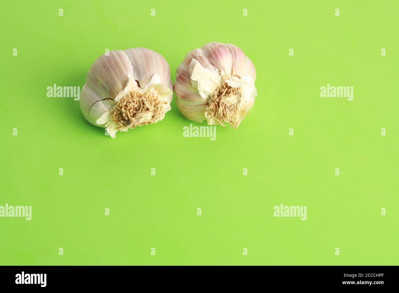 Heads of fresh raw garlic on a green surface Stock Photo - Alamy