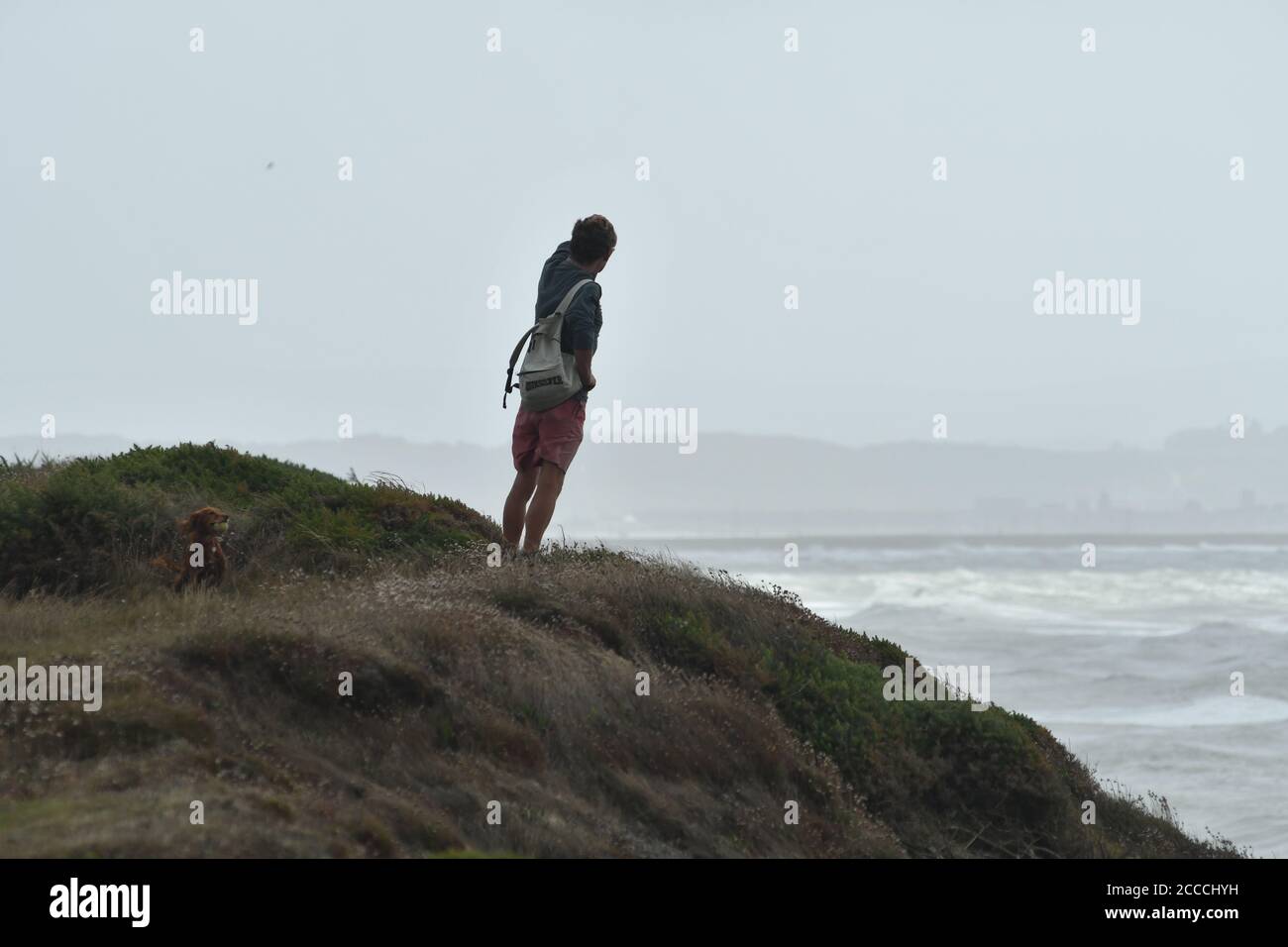 Man leaning into wind in a storm Stock Photo - Alamy