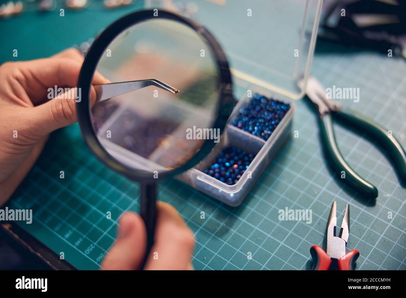 Hands of jewel maker zooming material element with a loupe Stock Photo ...