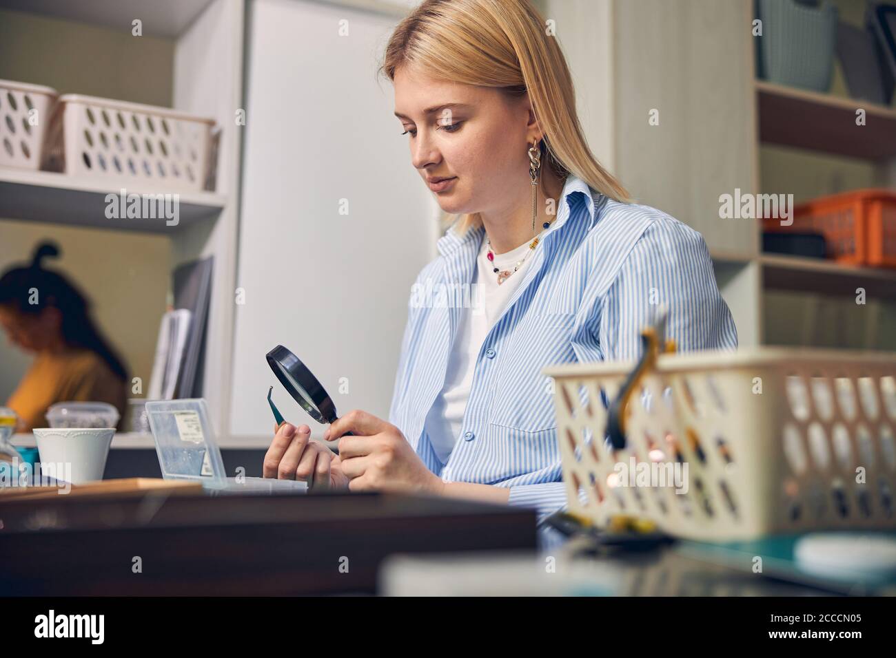Concentrated female scrutinizing bijouterie material with accuracy ...