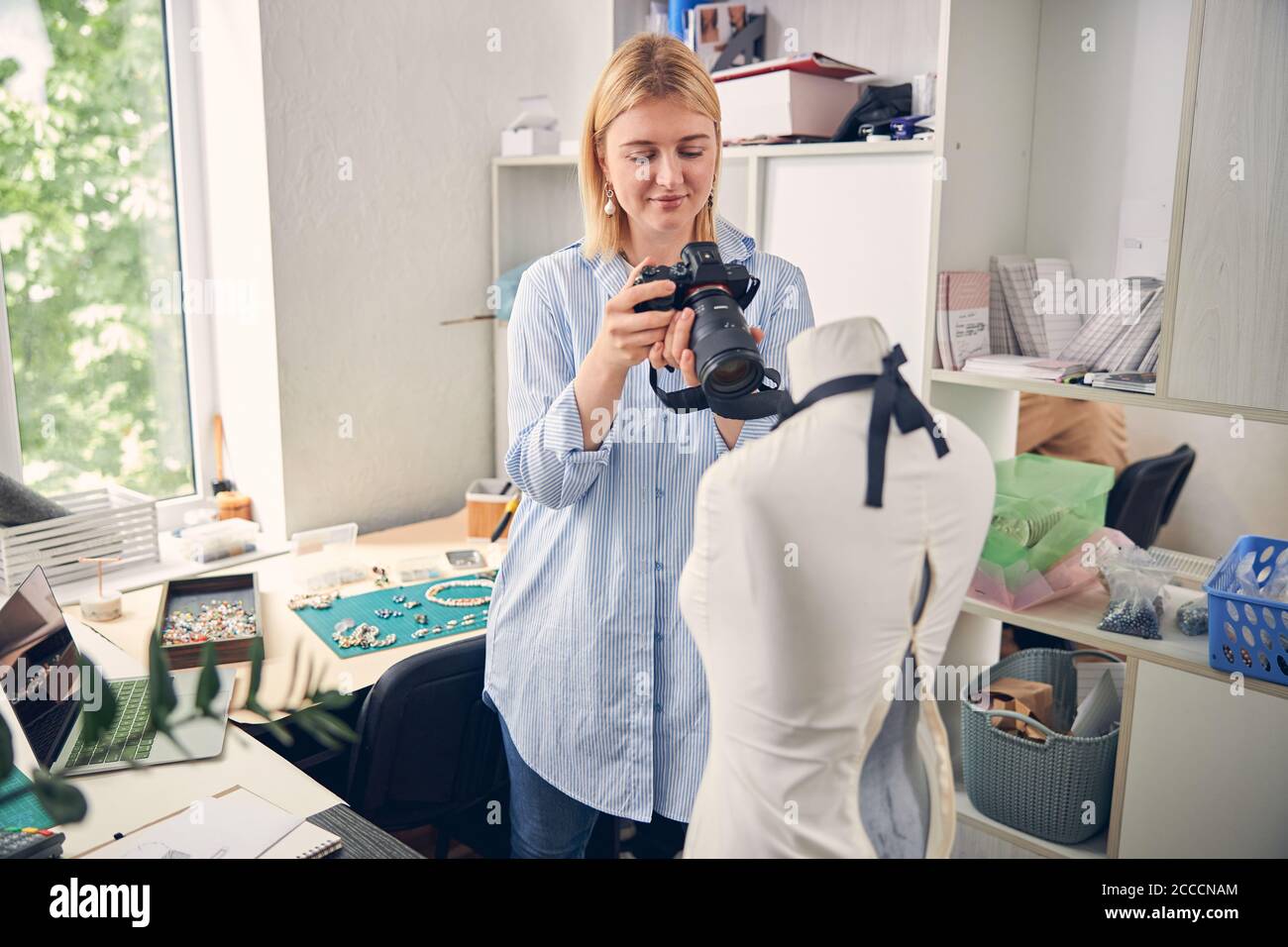Smiling female taking a picture in work studio Stock Photo - Alamy