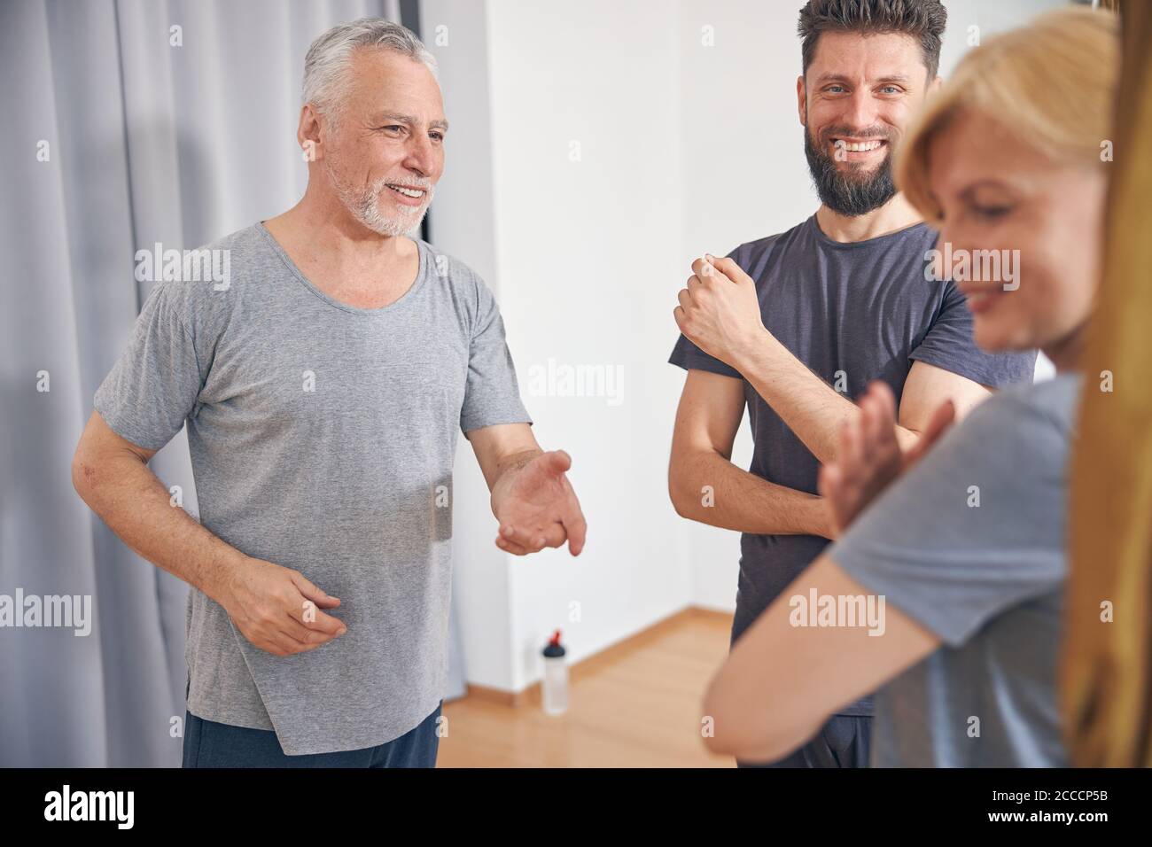 Coach standing next to a man and a woman Stock Photo - Alamy
