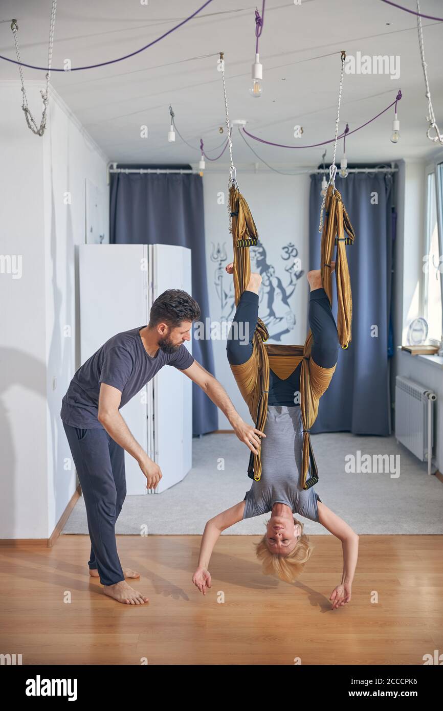 Fit calm Caucasian lady practicing flying yoga Stock Photo - Alamy