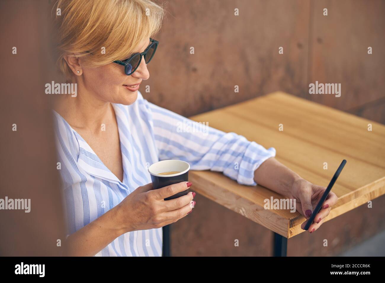 Happy blonde lady reading a text message Stock Photo - Alamy