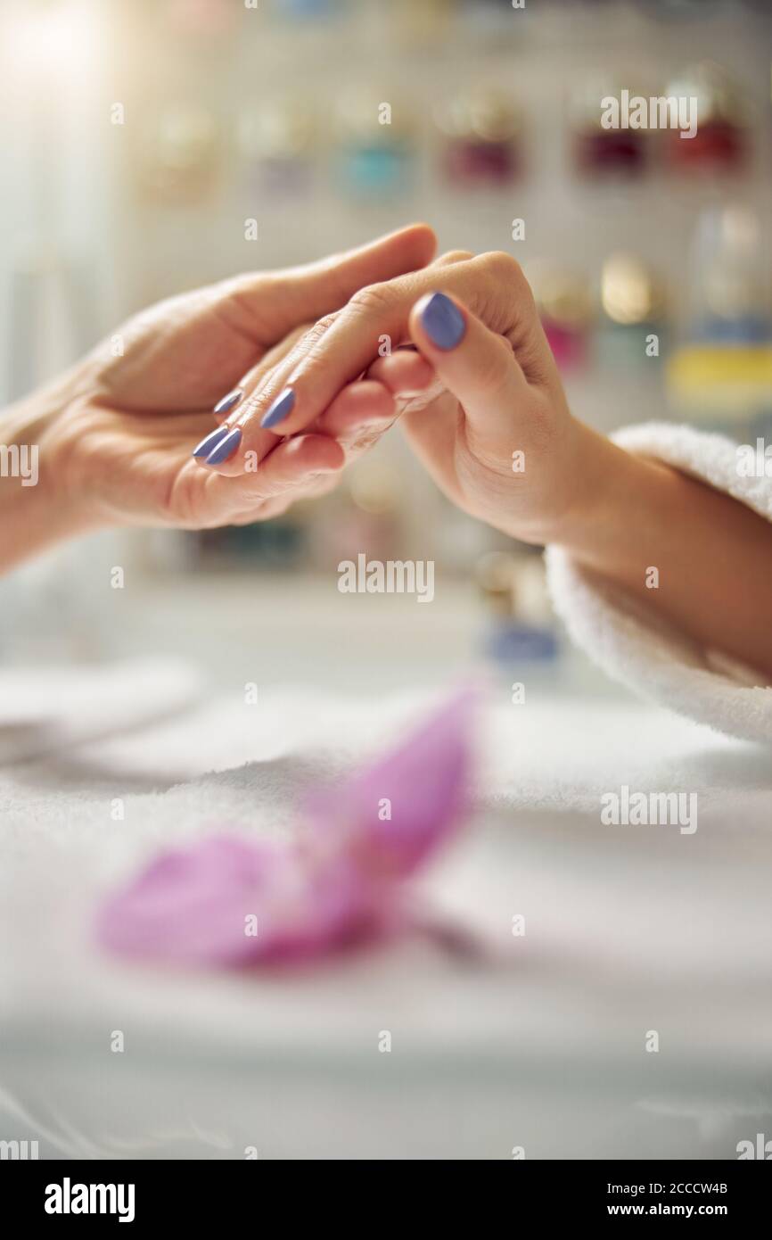 Nail artist and client connecting hands after procedure Stock Photo - Alamy