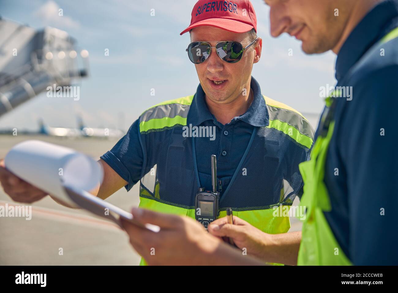 Two focused airport workers scrutinizing after-landing checklists Stock ...