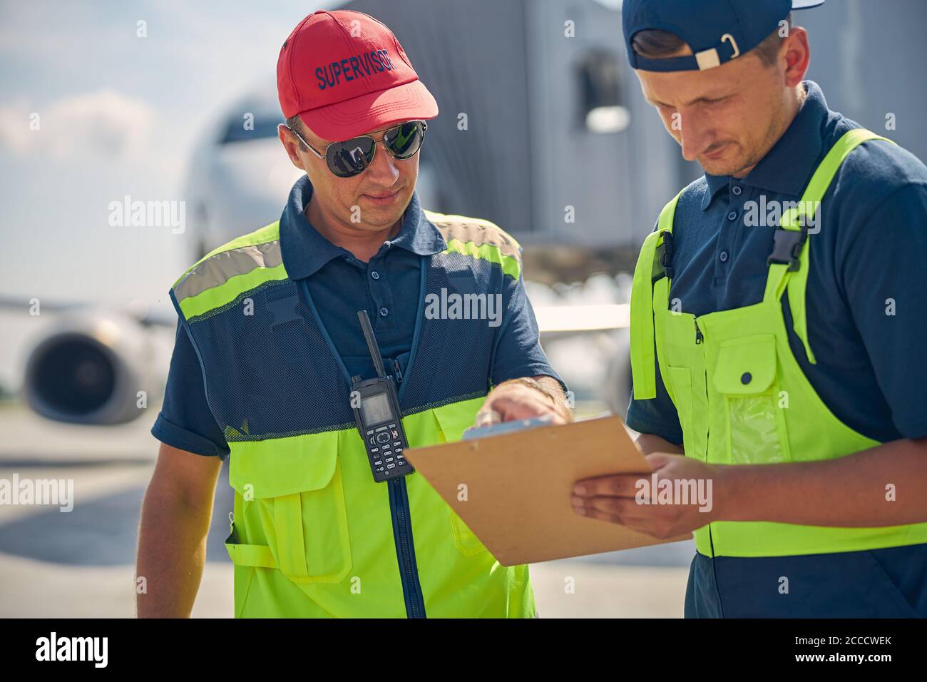 Airport ground crew workers examining hi-res stock photography and ...