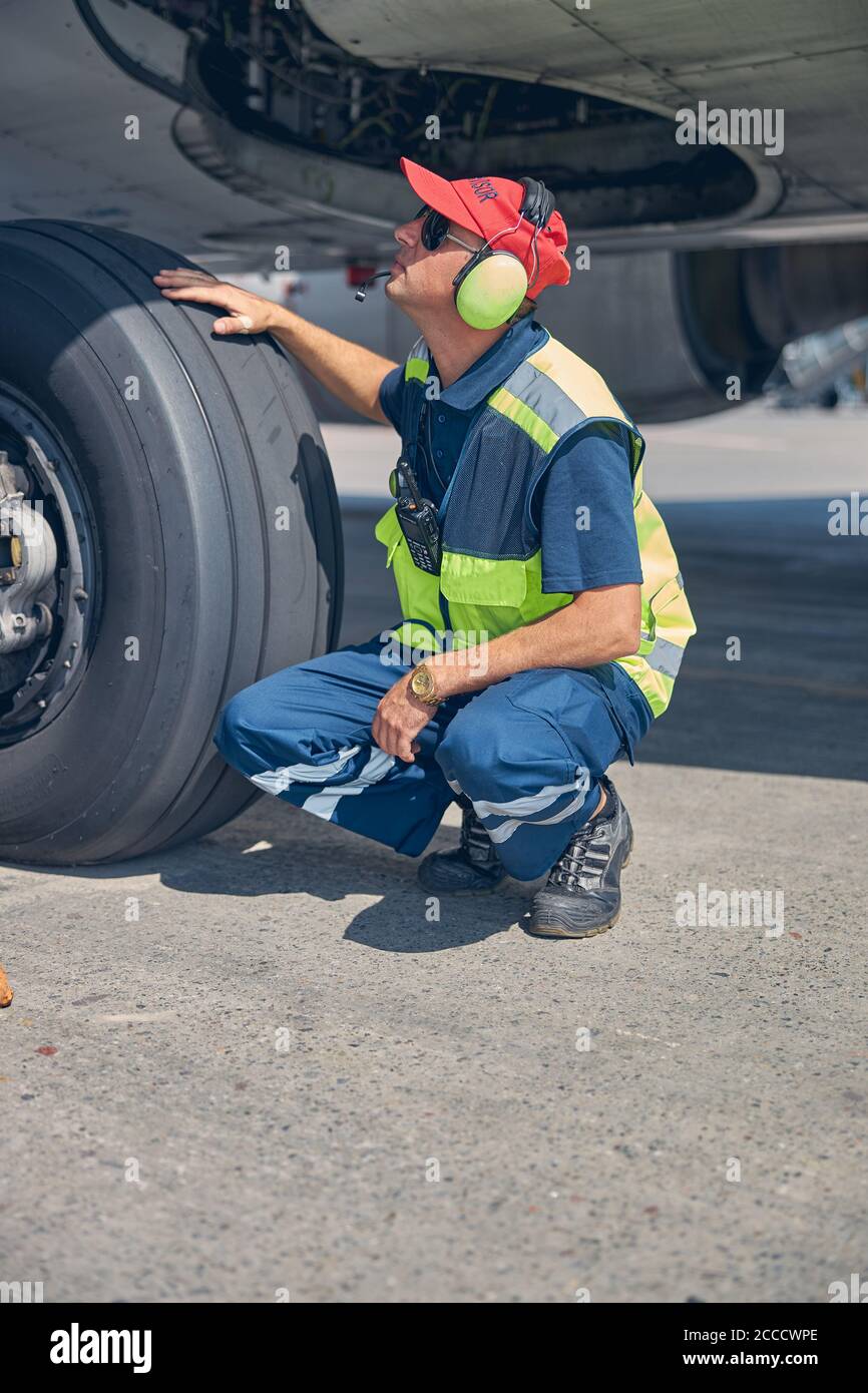 Airport worker performing a visual inspection of undercarriage Stock ...