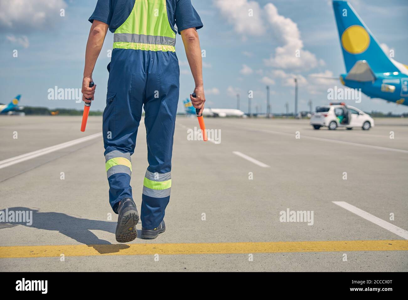 Caucasian airport worker heading towards an airplane Stock Photo - Alamy