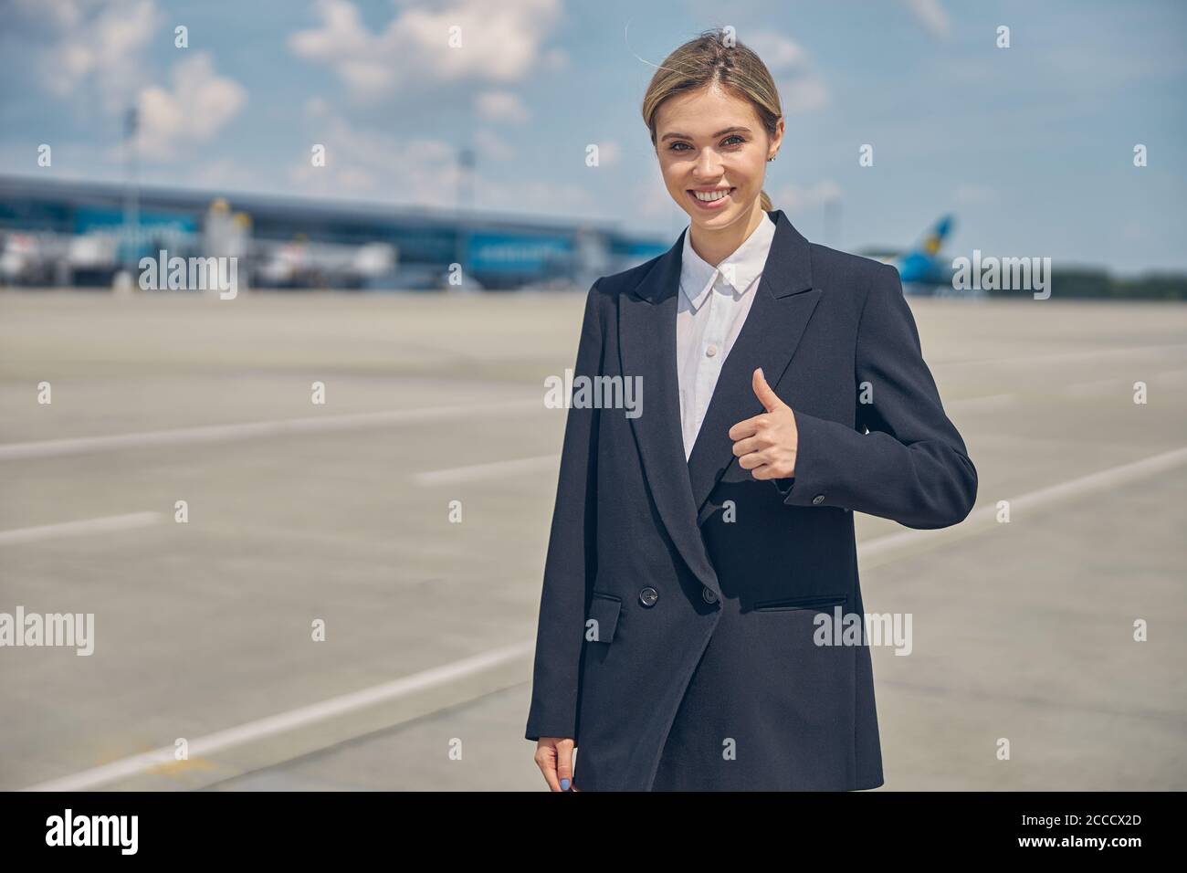 Smiling female airport worker on the runway Stock Photo - Alamy