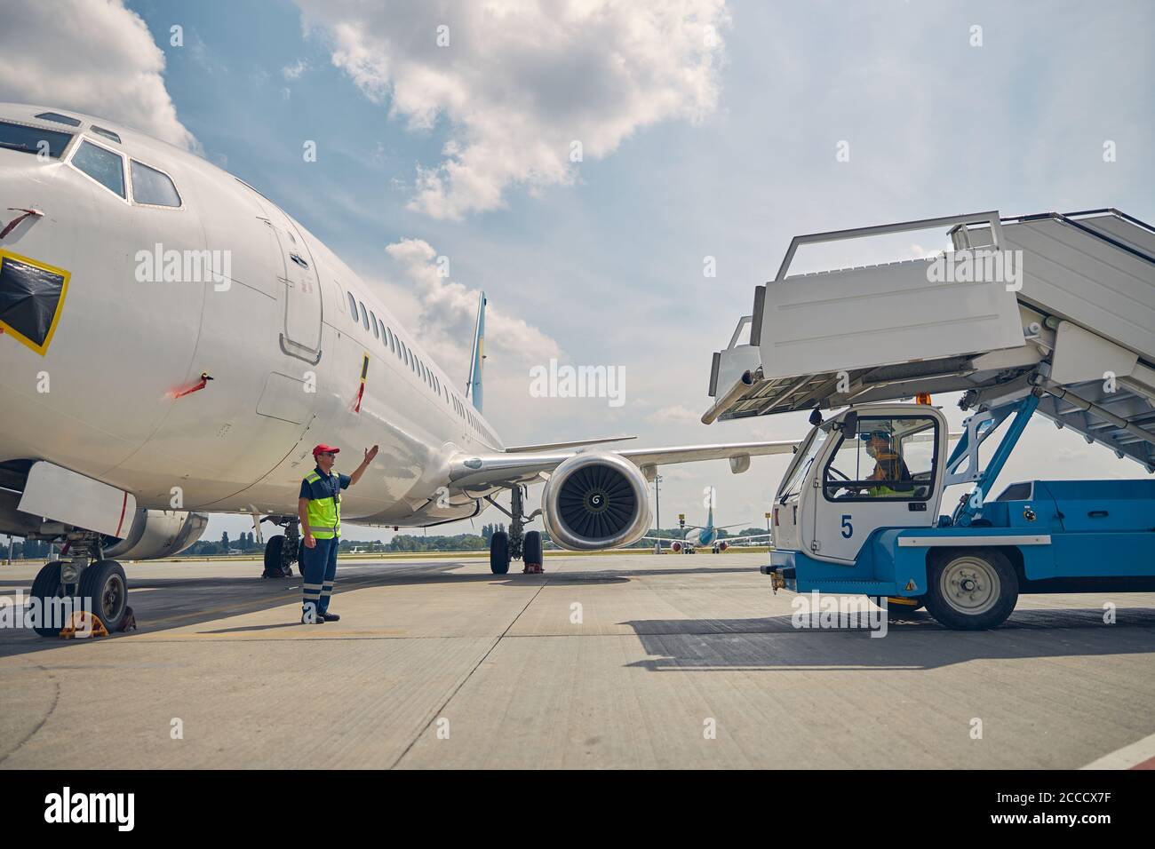Experienced airport worker directing the ground vehicle operator Stock ...