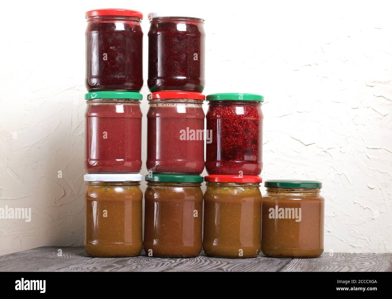 Jam in glass jars. It stands in the form of a pyramid against the ...