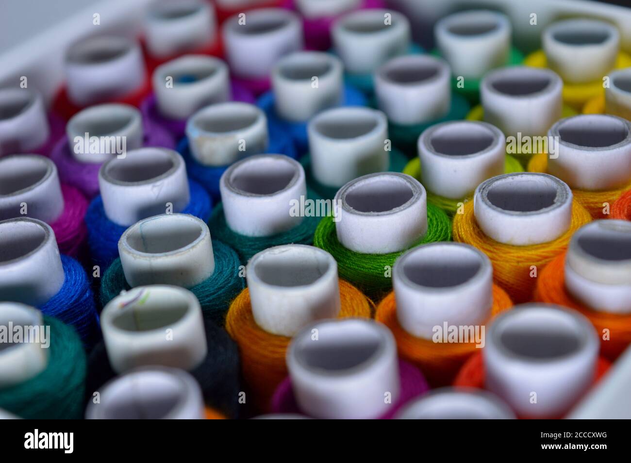 colourful thread rolls arranged in a box. Some parts of the image are ...