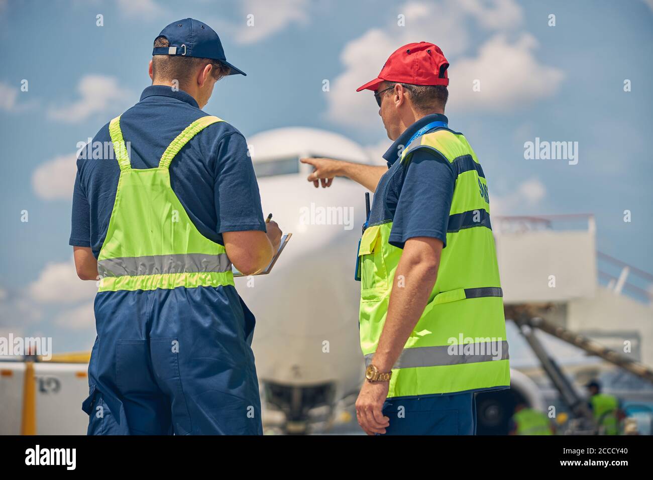 Skilled airport workers conducting a post-flight inspection Stock Photo ...