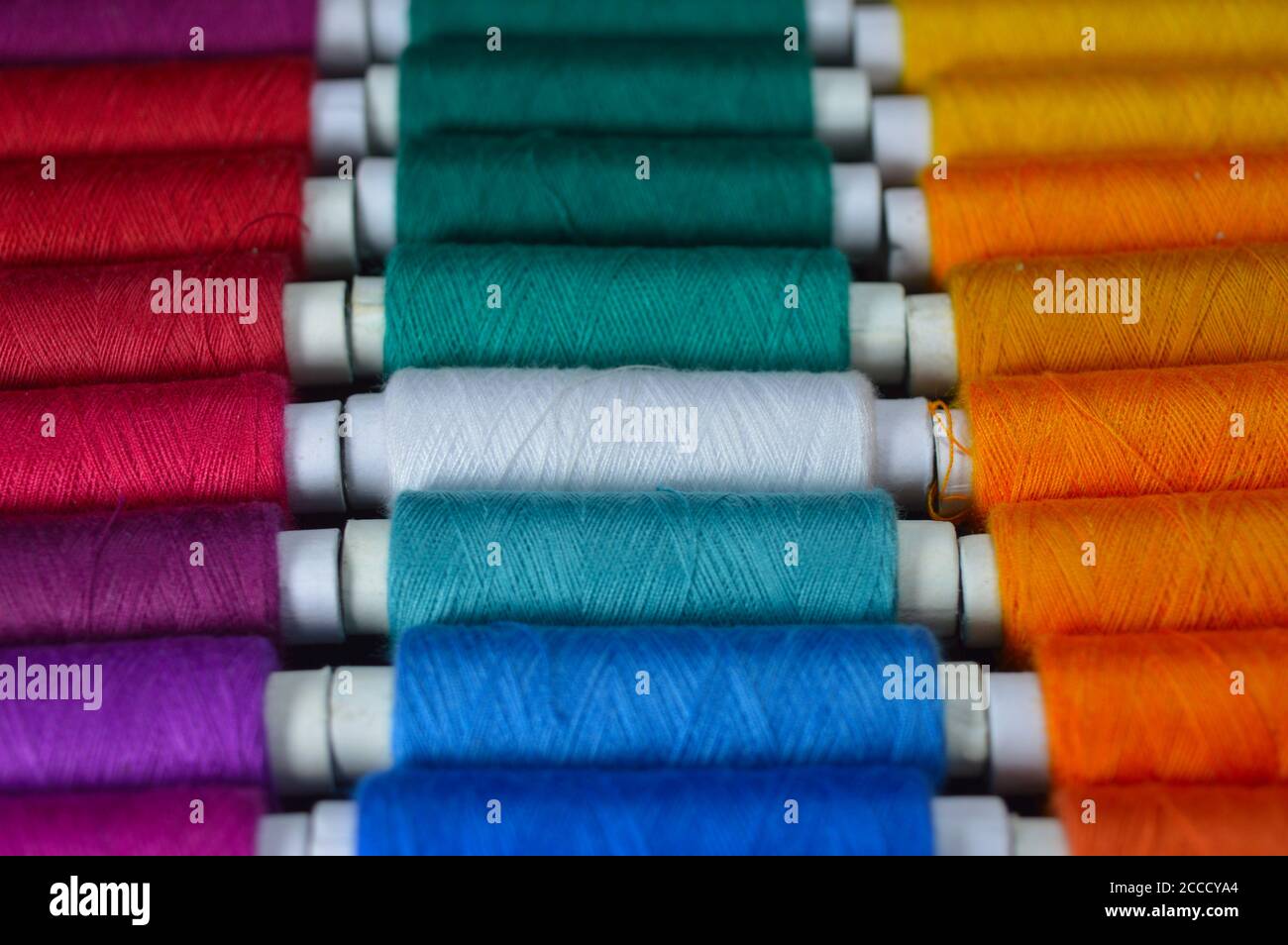 colourful thread rolls arranged in a box. Some parts of the image are ...