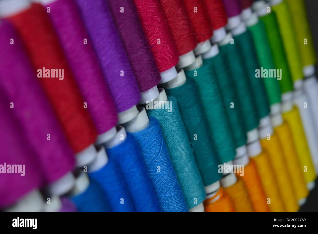 colourful thread rolls arranged in a box. Some parts of the image are ...