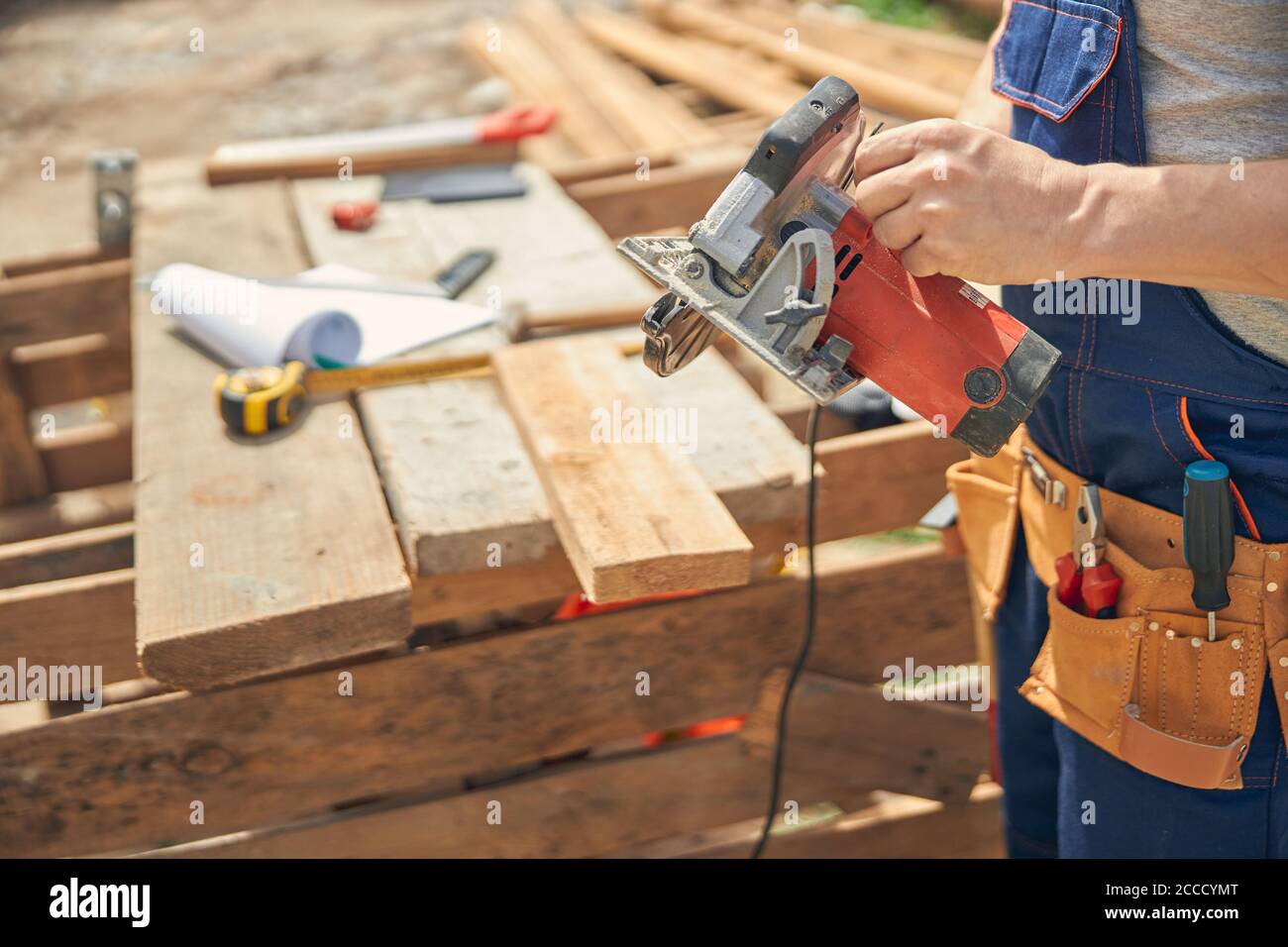 Builder getting ready for cutting wood outdoors Stock Photo - Alamy