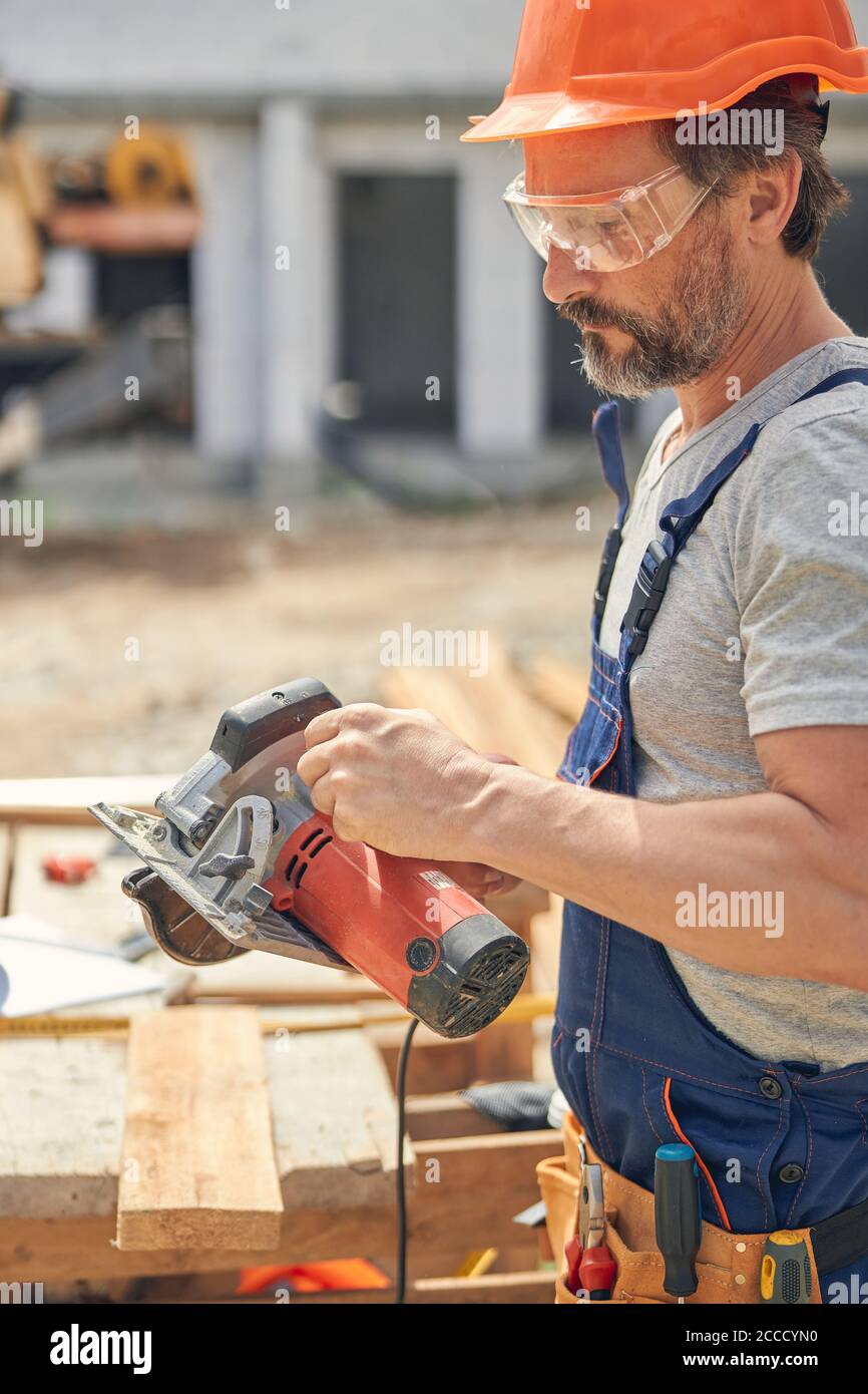 Focused carpenter getting ready for cutting wood Stock Photo - Alamy