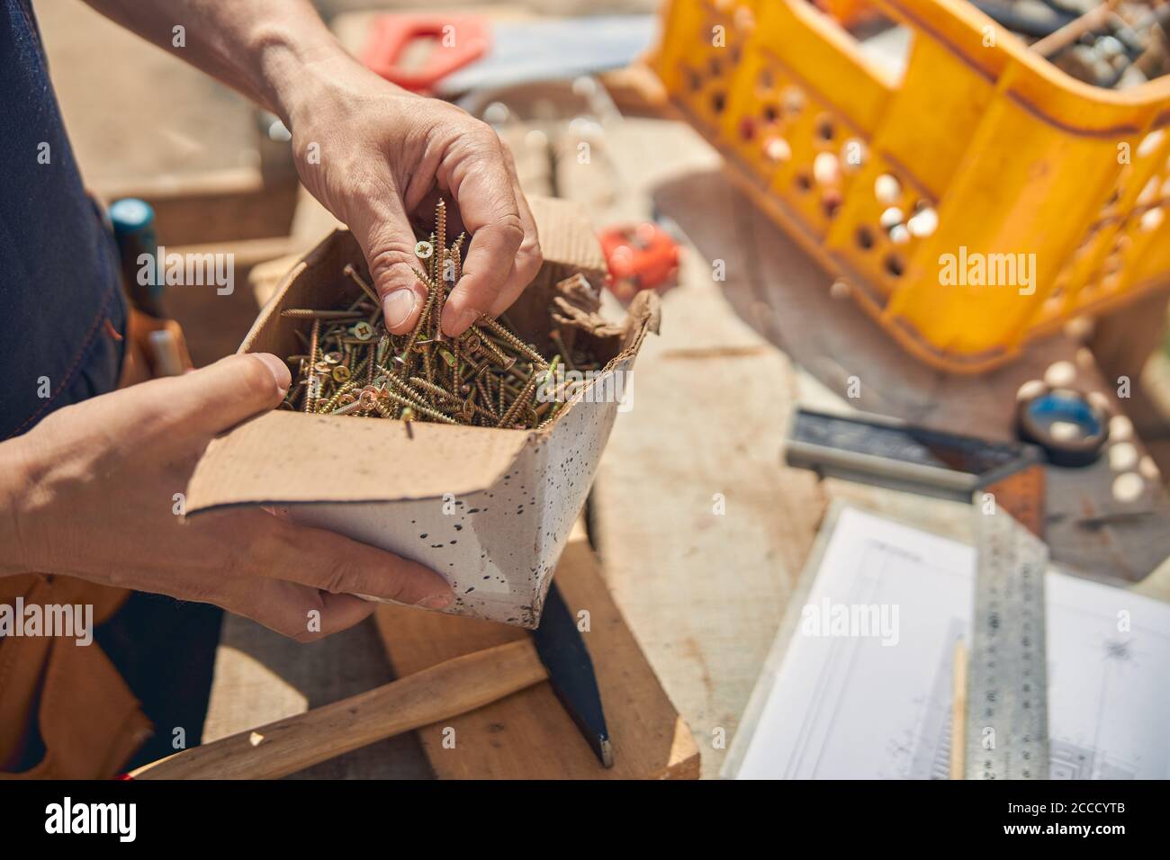 Male worker choosing the right metal bolts Stock Photo - Alamy