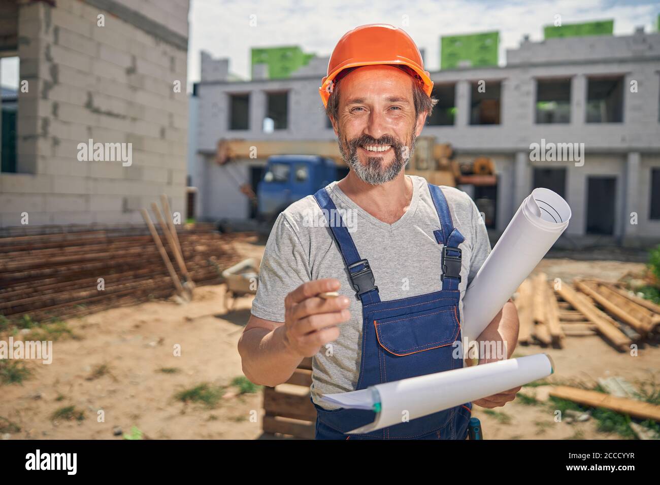 Construction worker with a pencil looking ahead Stock Photo - Alamy