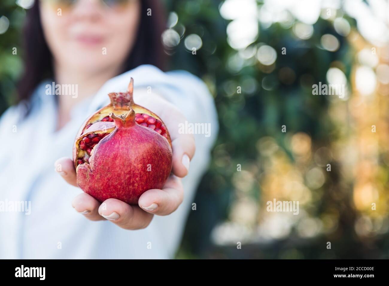 Hands opening pomegranate hi-res stock photography and images - Alamy
